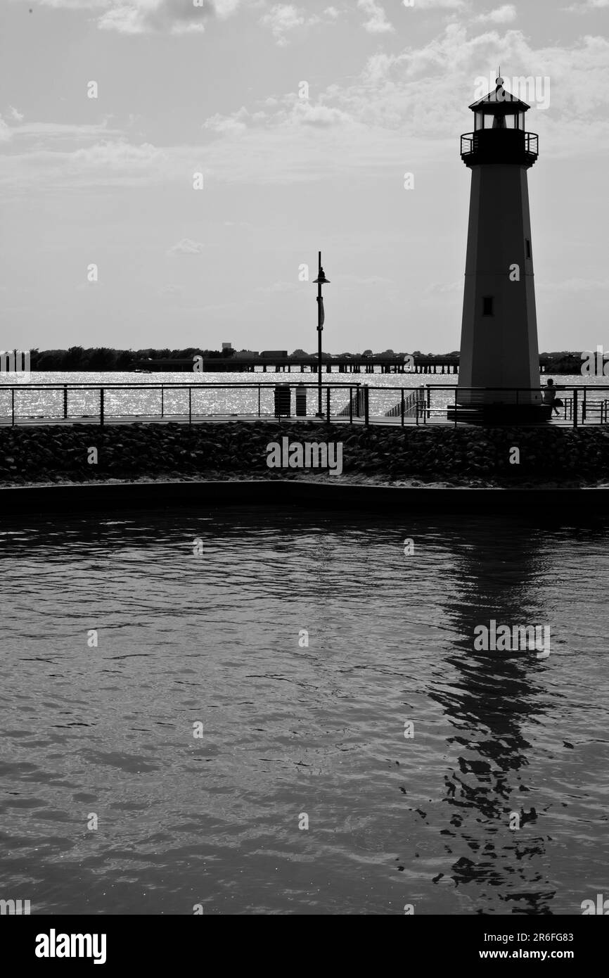 A traditional lighthouse on a windswept shoreline at a cloudy day, with ...
