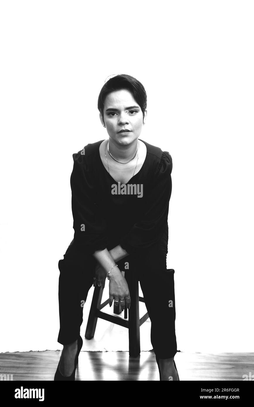 A black and white portrait of an attractive female seated in a chair ...