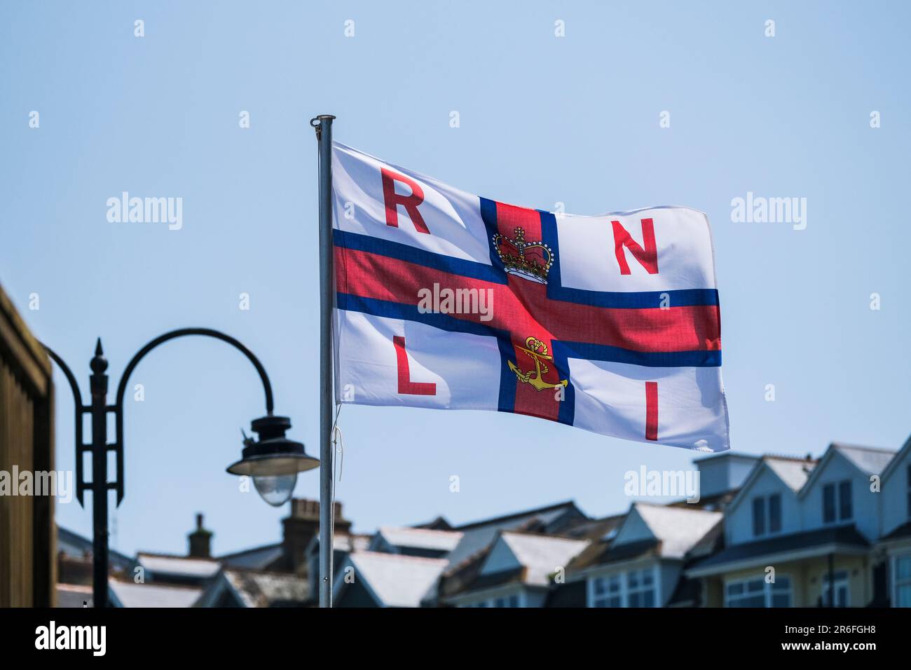 A RNLI flag fluttering on a flagpole in Newquay in Cornwall in the UK ...