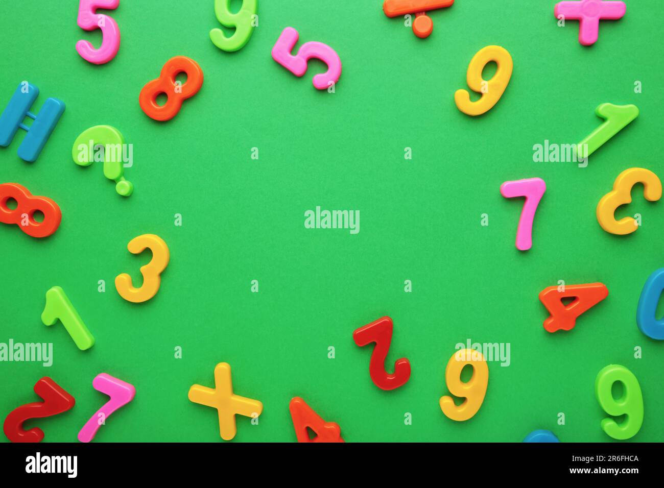 Many colorful numbers on green background with copy space. Top view ...