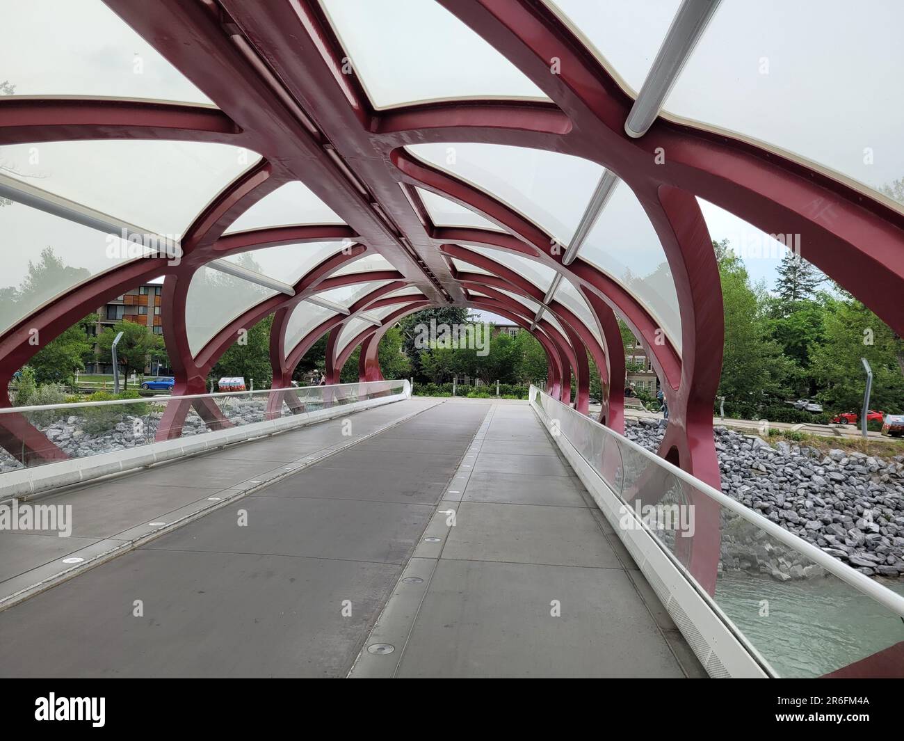 An empty stone bridge with red arches spanning the river, surrounded by ...