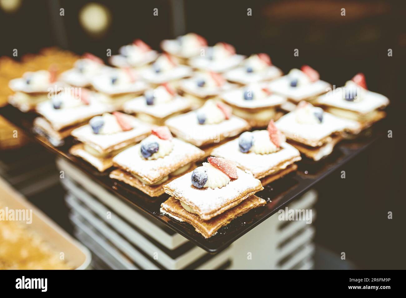 A plate with a selection of sweet square-shaped cakes and pastries ...