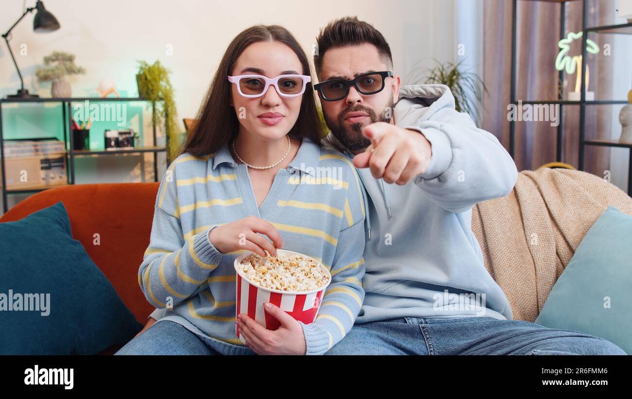 Excited young family marriage couple man woman eating popcorn and ...