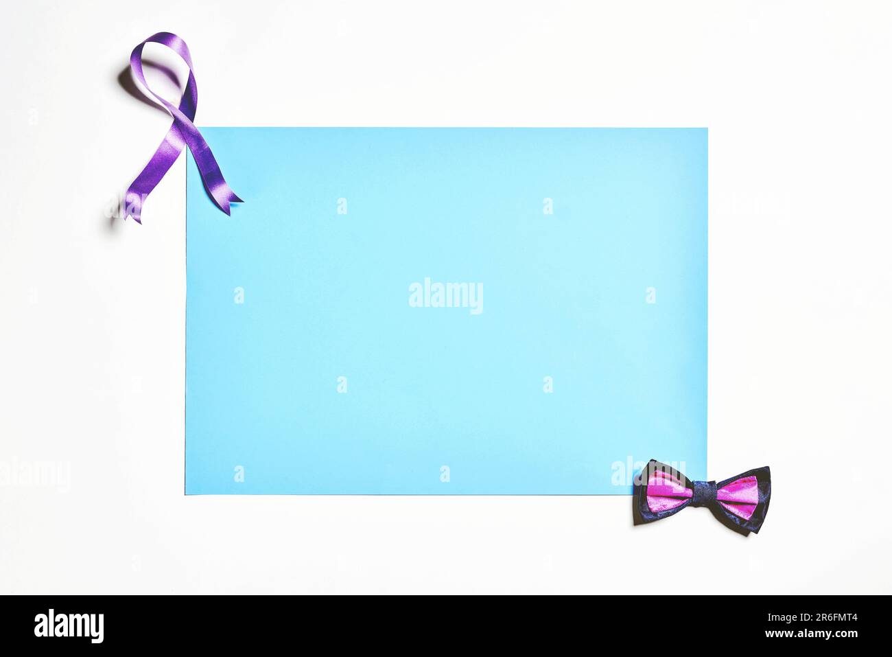 A crisp blue sheet of paper with a regal purple ribbon tied on top of ...