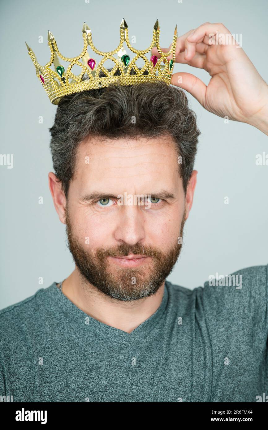 Young man with golden crown of king over gray background. Handsome man ...