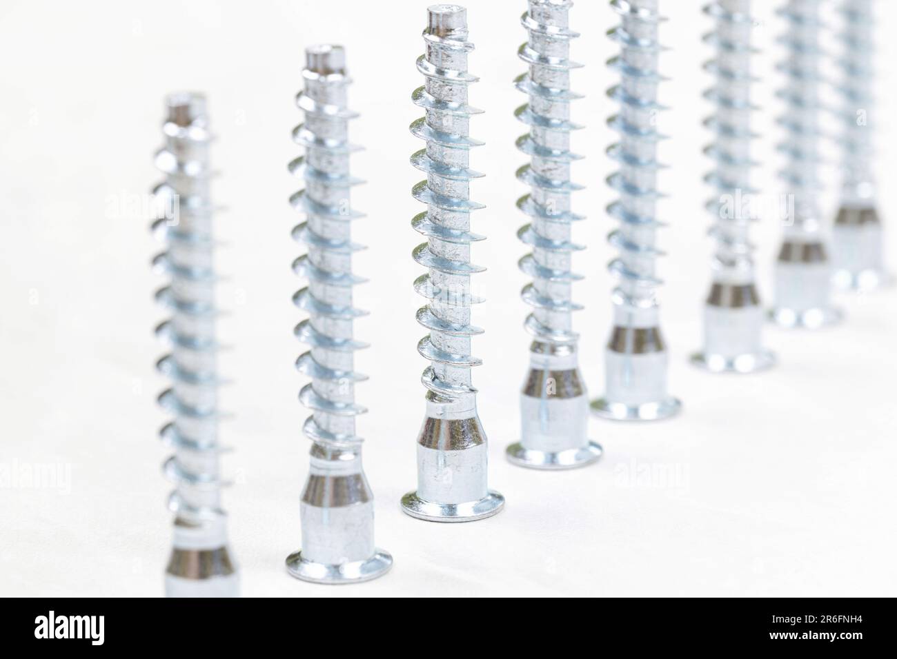 A silver and white abstract background featuring several screws and ...