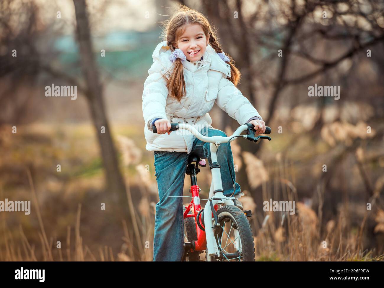 Happy cute little girl on a bicycle in the spring Stock Photo - Alamy