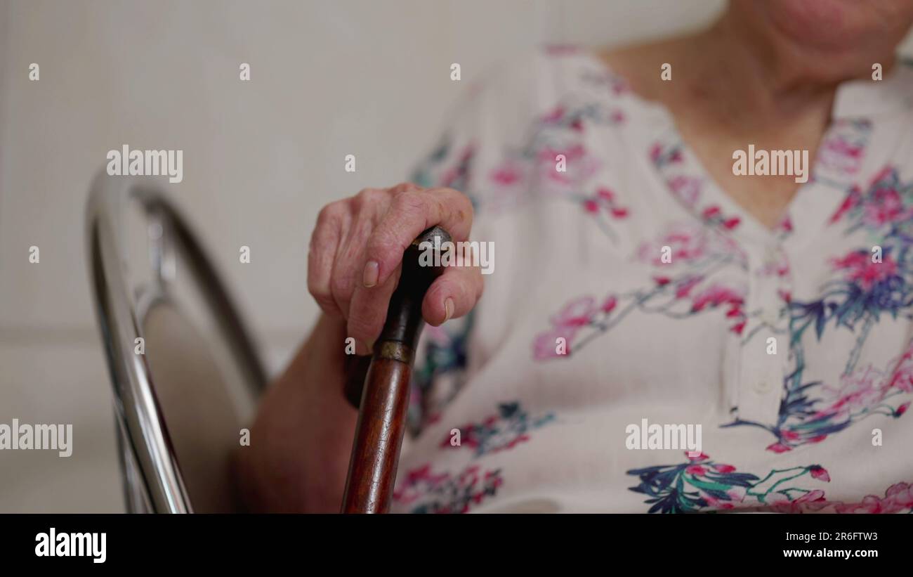 Close-up of elderly woman hands holding walking stick, scene depiction ...