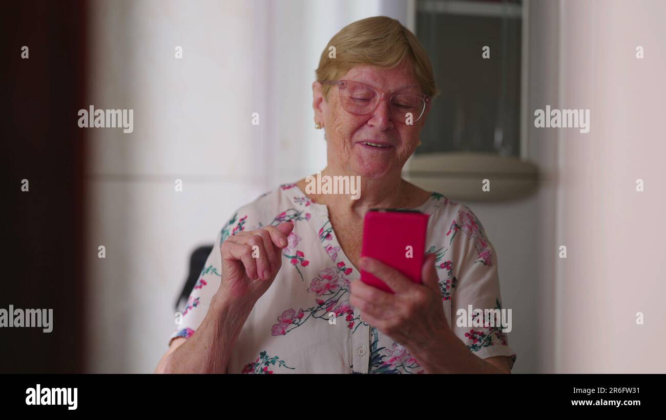 Candid senior woman waving hello to family member speaking on video ...