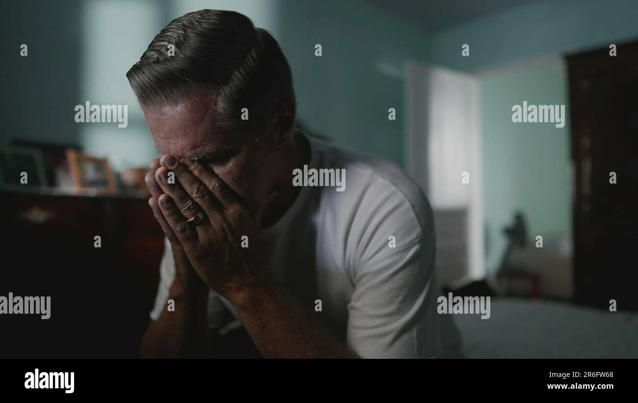 Desperate senior man covering face suffering from despair and lonliness ...