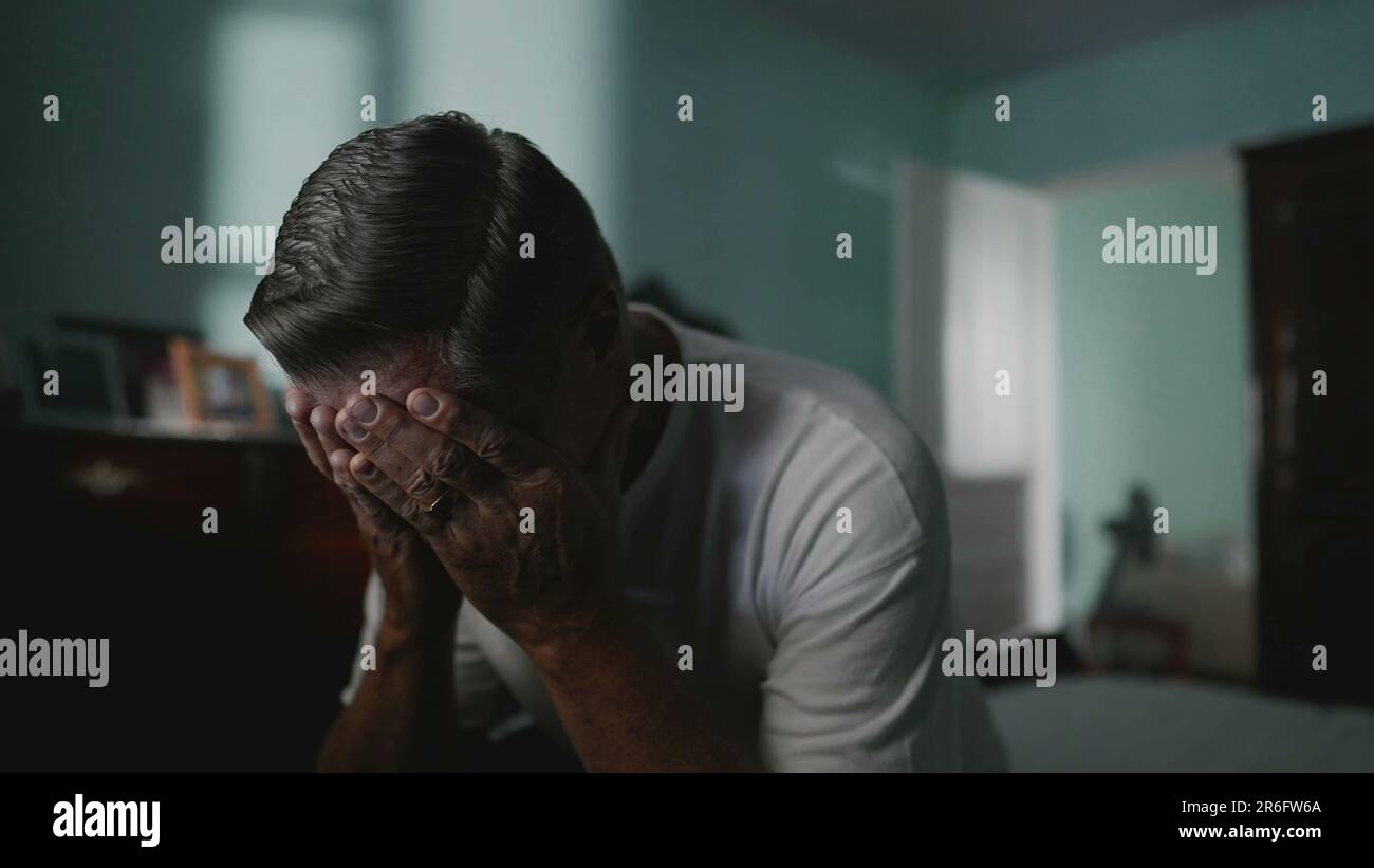 Desperate senior man covering face suffering from despair and lonliness ...