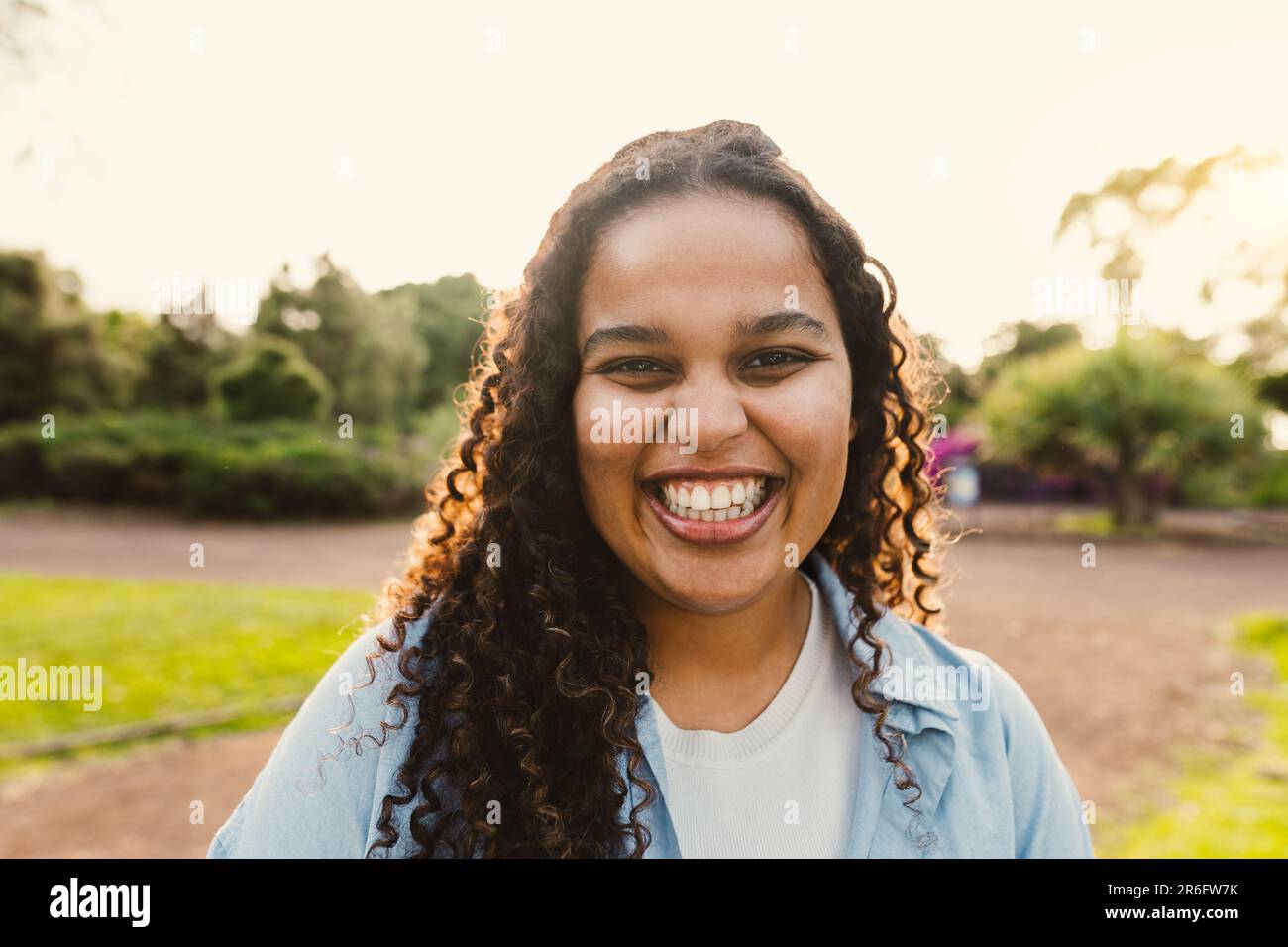Happy African young girl having fun smiling into the camera in public ...