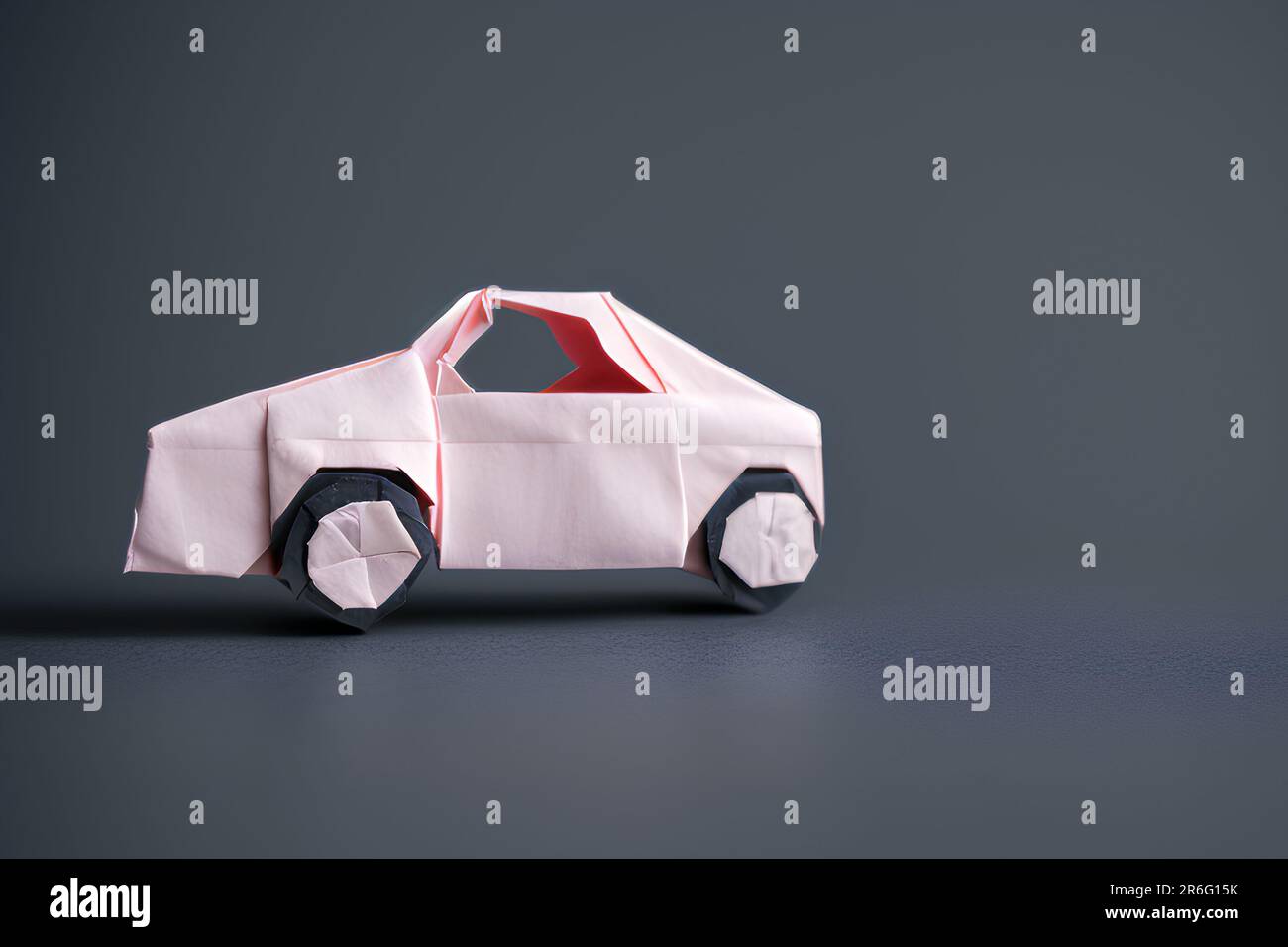 A vibrant pink origami-style car with sleek black wheels sits atop a ...