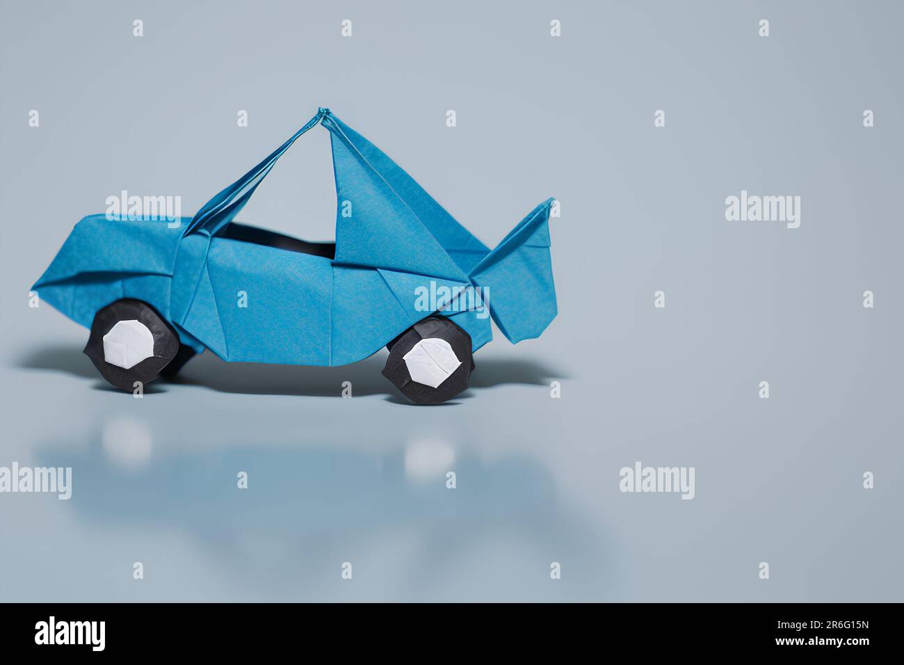 An origami-style car with a blue exterior on a reflective gray ...