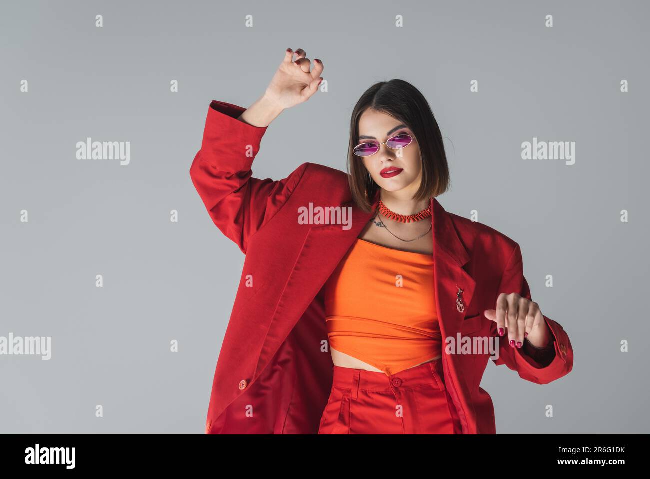 fashionable gen z, young brunette woman with short hair posing in pink ...