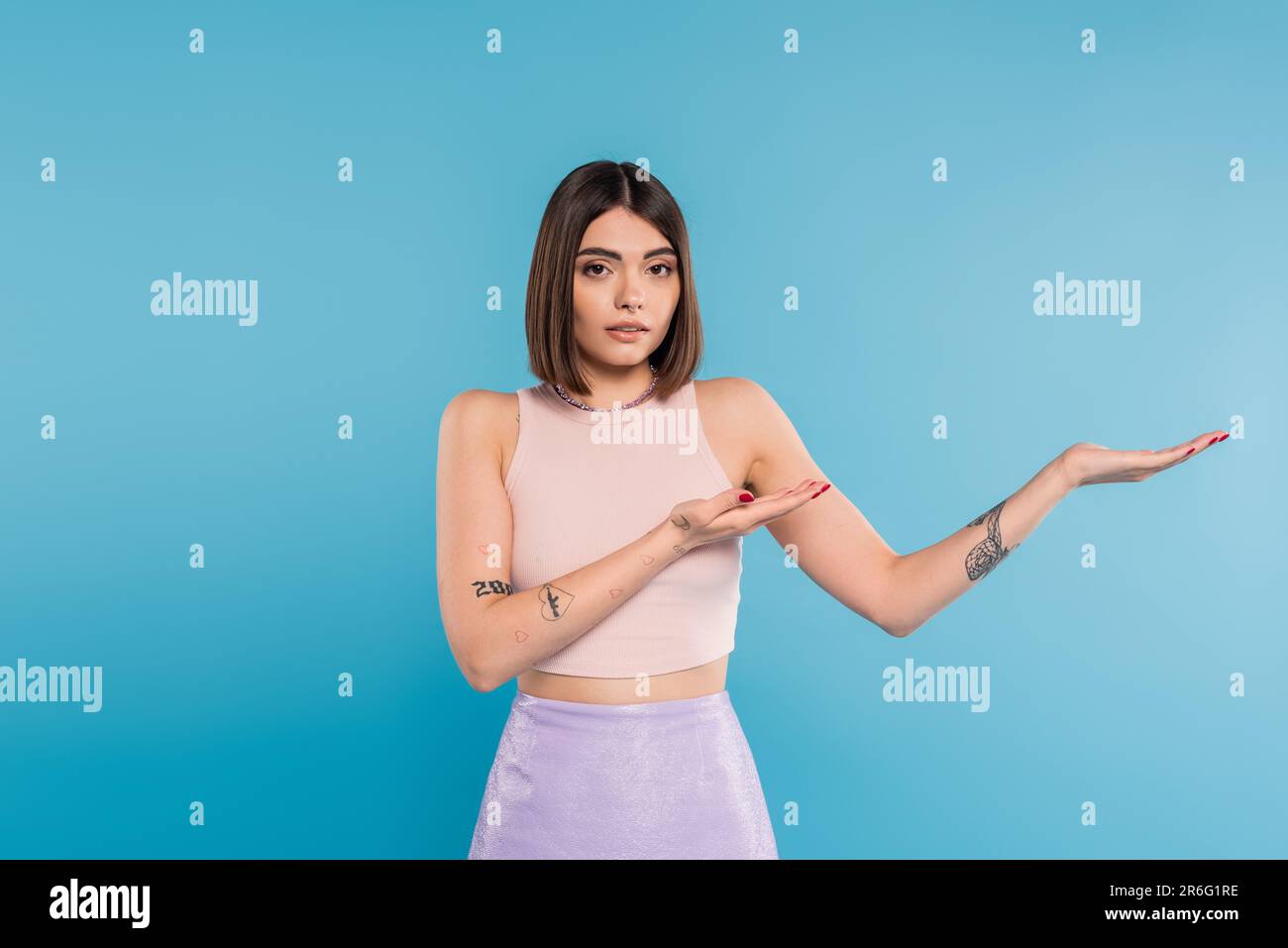 brunette young woman with short hair demonstrating something on camera ...