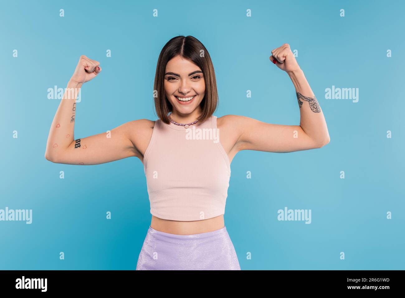 women power, cheerful young woman with short hair, tattoos and nose ...