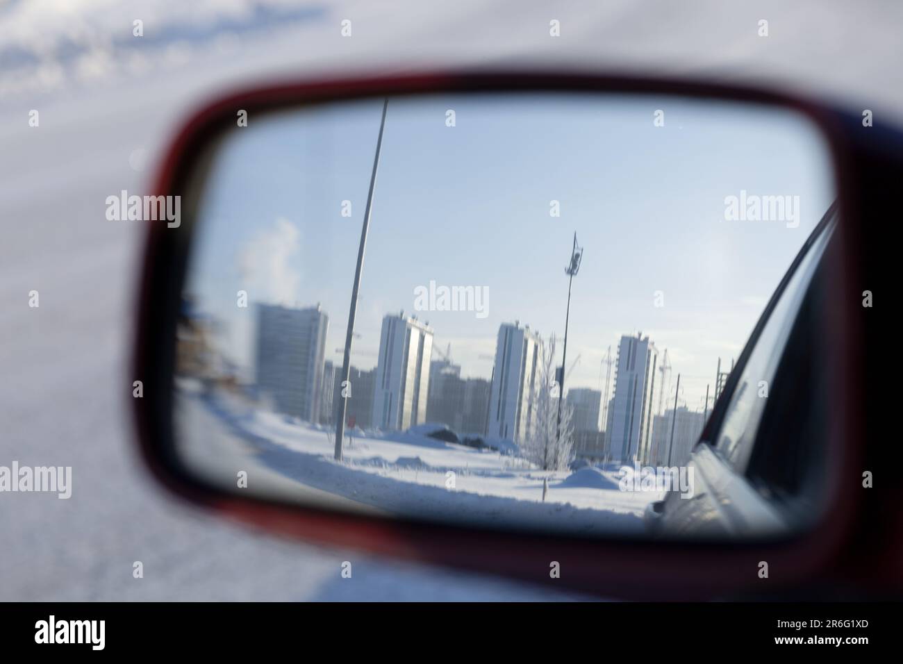 Reflection of the cityscape in the rear-view mirror of the car on a ...