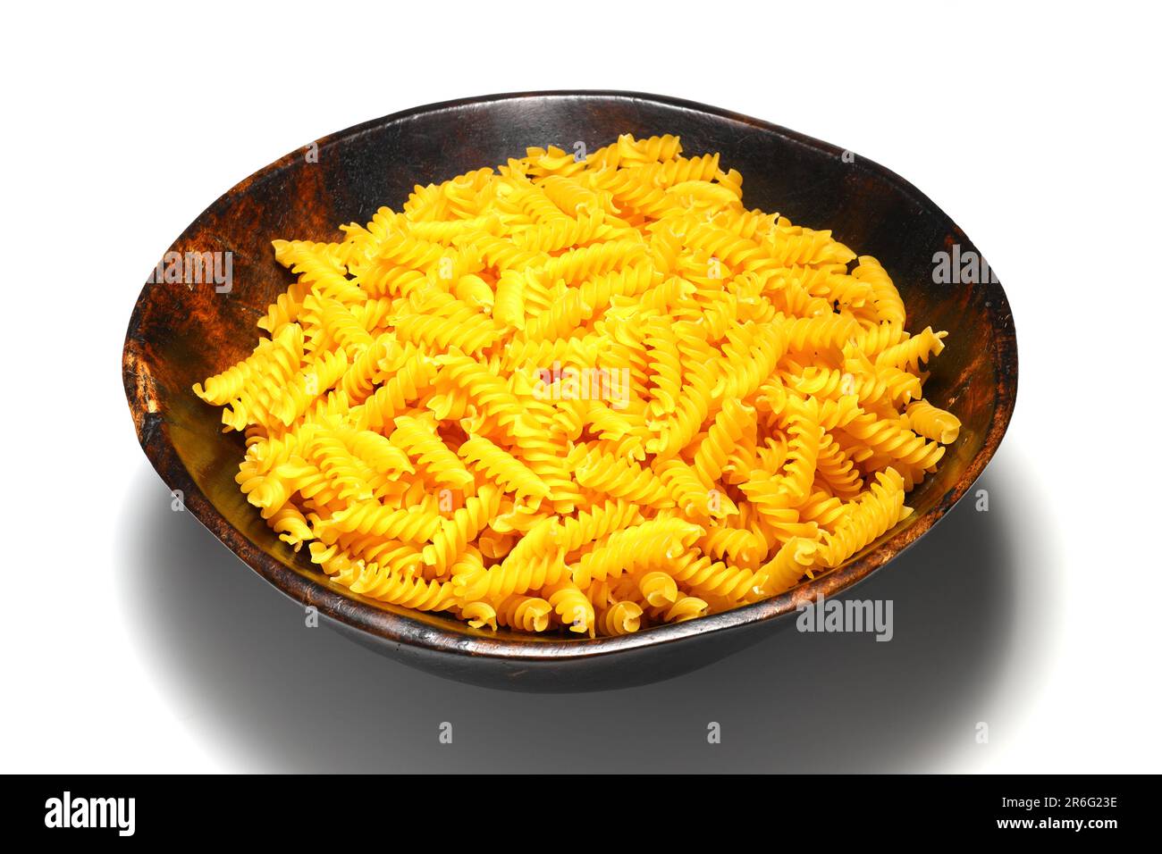 pile of spiral pasta scattered on light background. corkscrew shaped ...