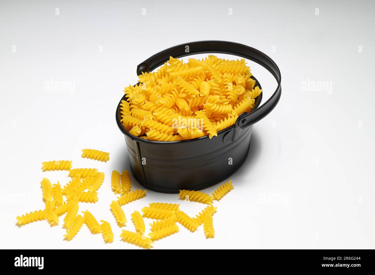 pile of spiral pasta scattered on light background. corkscrew shaped ...