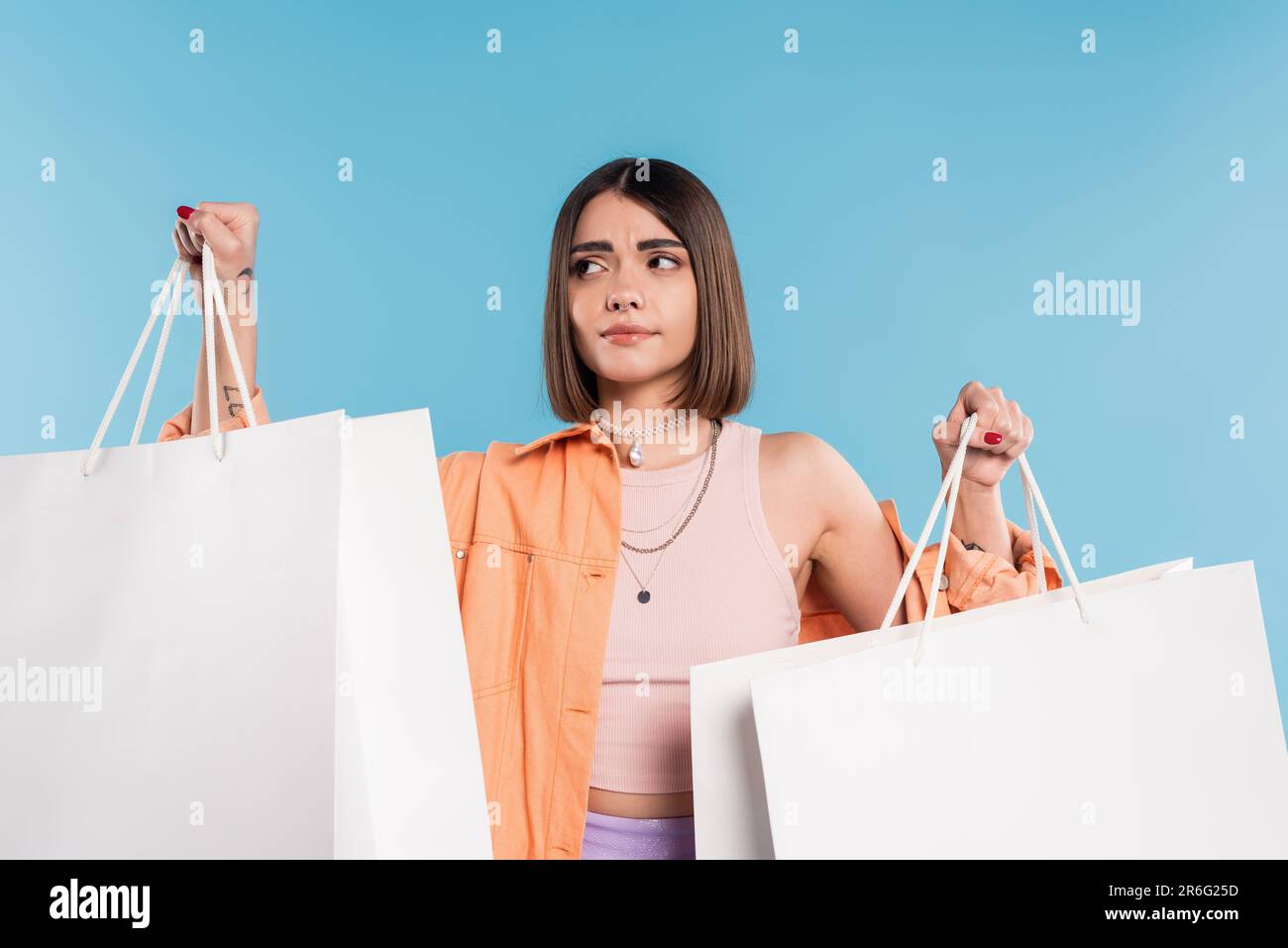 shopping spree, confused young woman in trendy outfit posing with ...