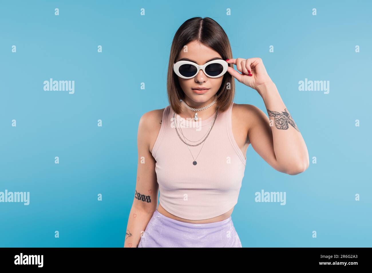 gen z fashion, brunette young woman with short hair in tank top, skirt ...