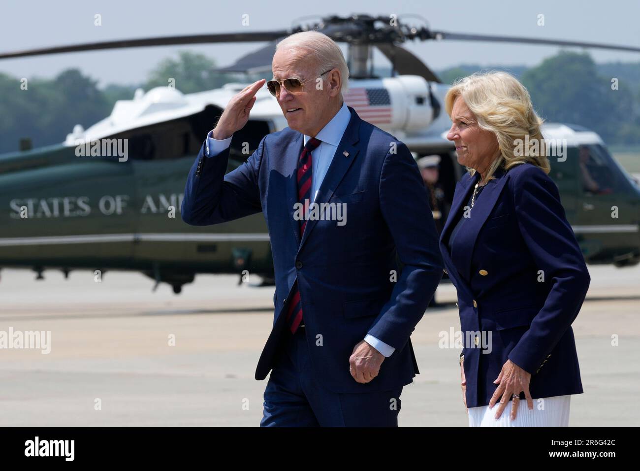 President Joe Biden returns a salute as he and first lady Jill Biden ...