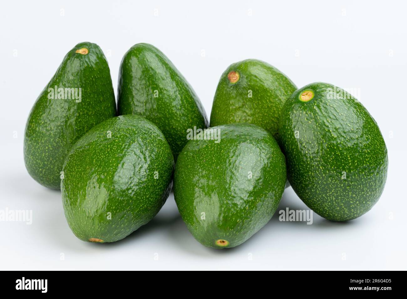 Shiny green avocado pile close up view isolated on white studio ...