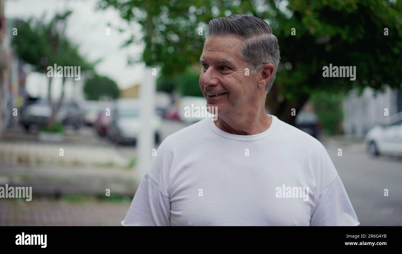 Happy older man walking outside in street. A middle-aged joyful male ...