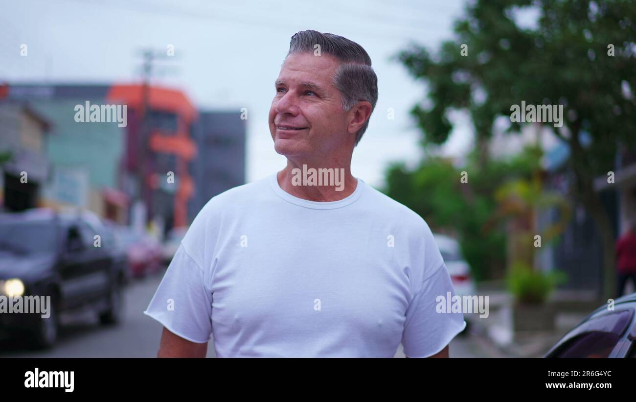Happy senior man walking in street in daylight. A smiling middle-age ...