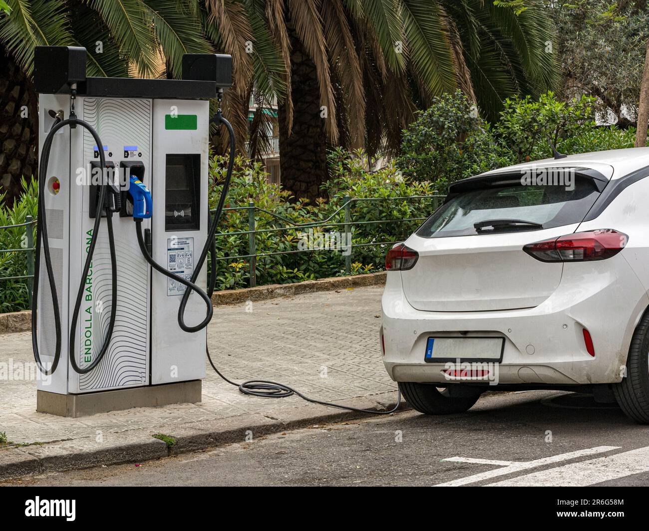 Hybrid car recharging the battery at a public recharging point, on a ...