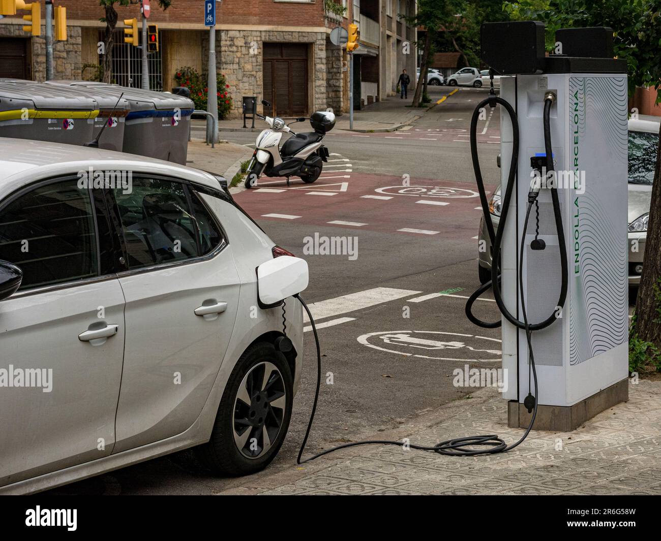 Hybrid car recharging the battery at a public recharging point, on a ...