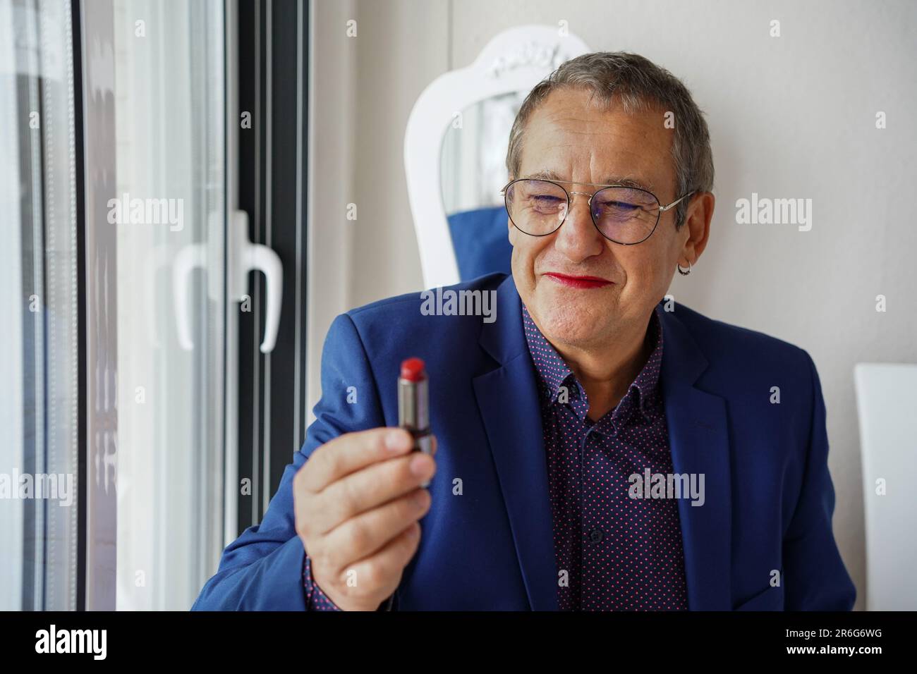 an older man looks at a lipstick. boys who put on makeup in gay pride ...
