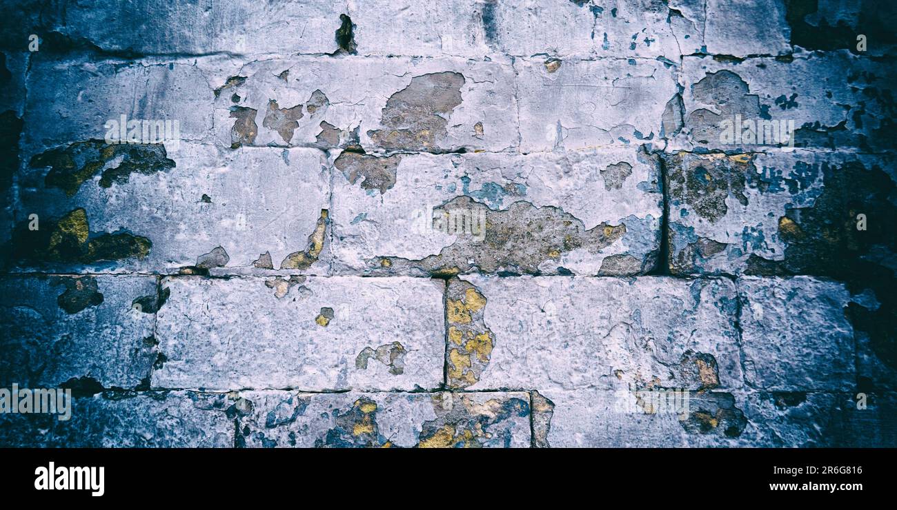 An old white brick wall with chipped paint. Vintage camera effect added ...