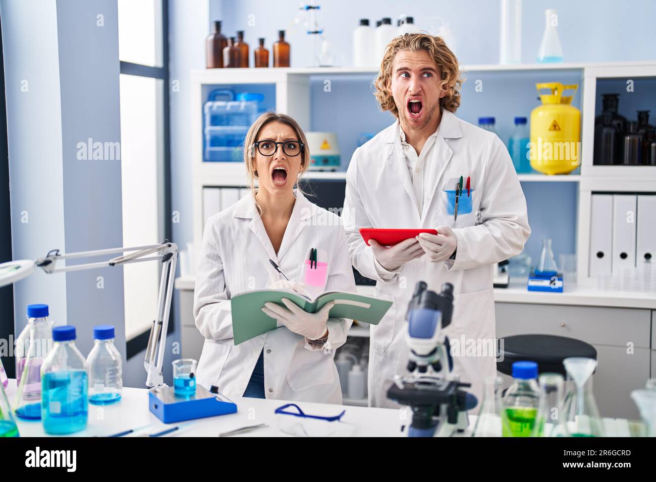 Two people working at scientist laboratory angry and mad screaming ...