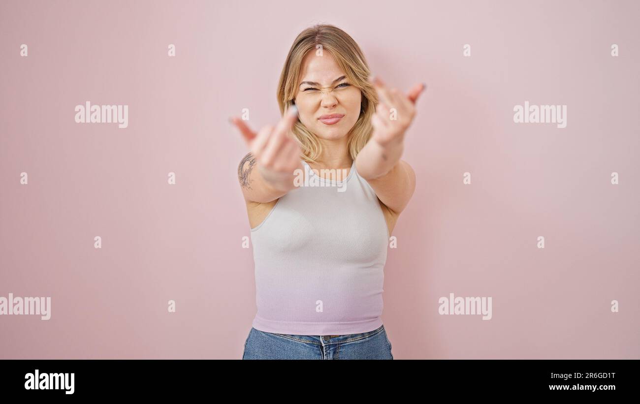 Young blonde woman smiling confident doing middle finger gesture over ...