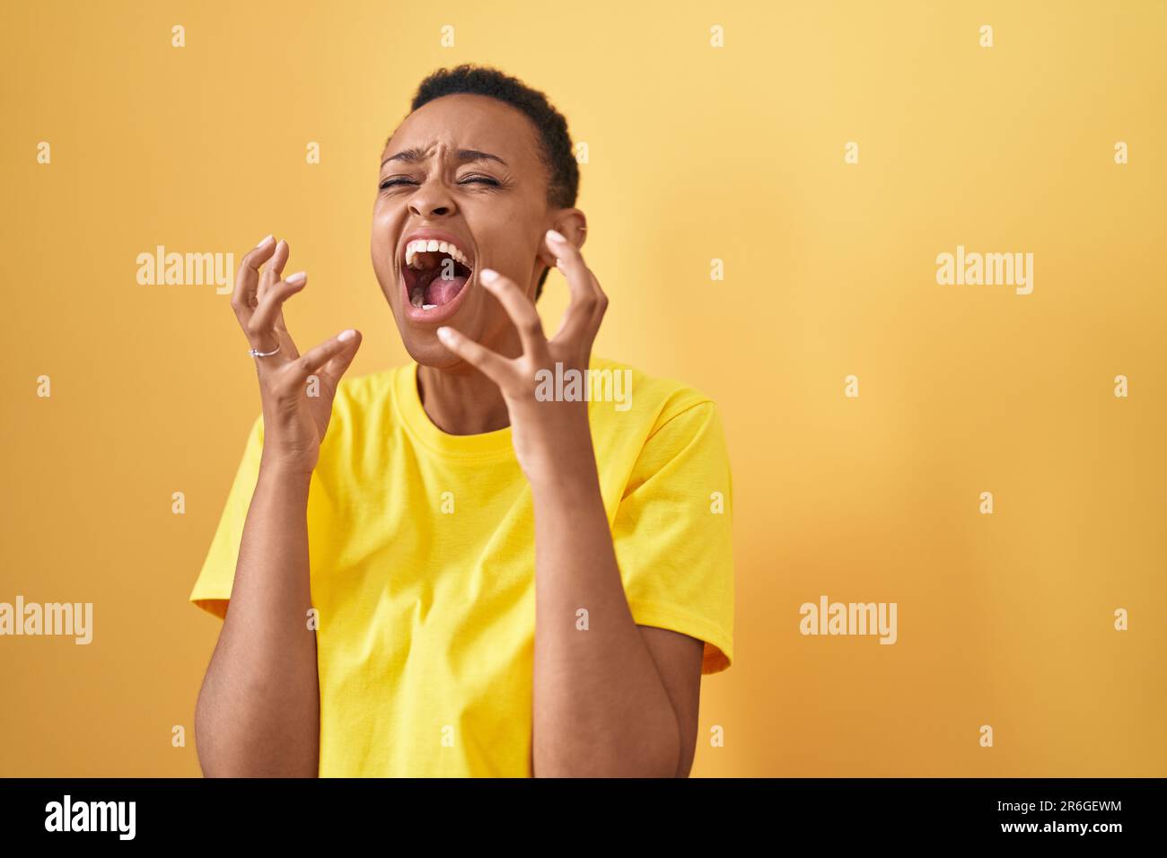African american woman screaming over isolated yellow background Stock ...