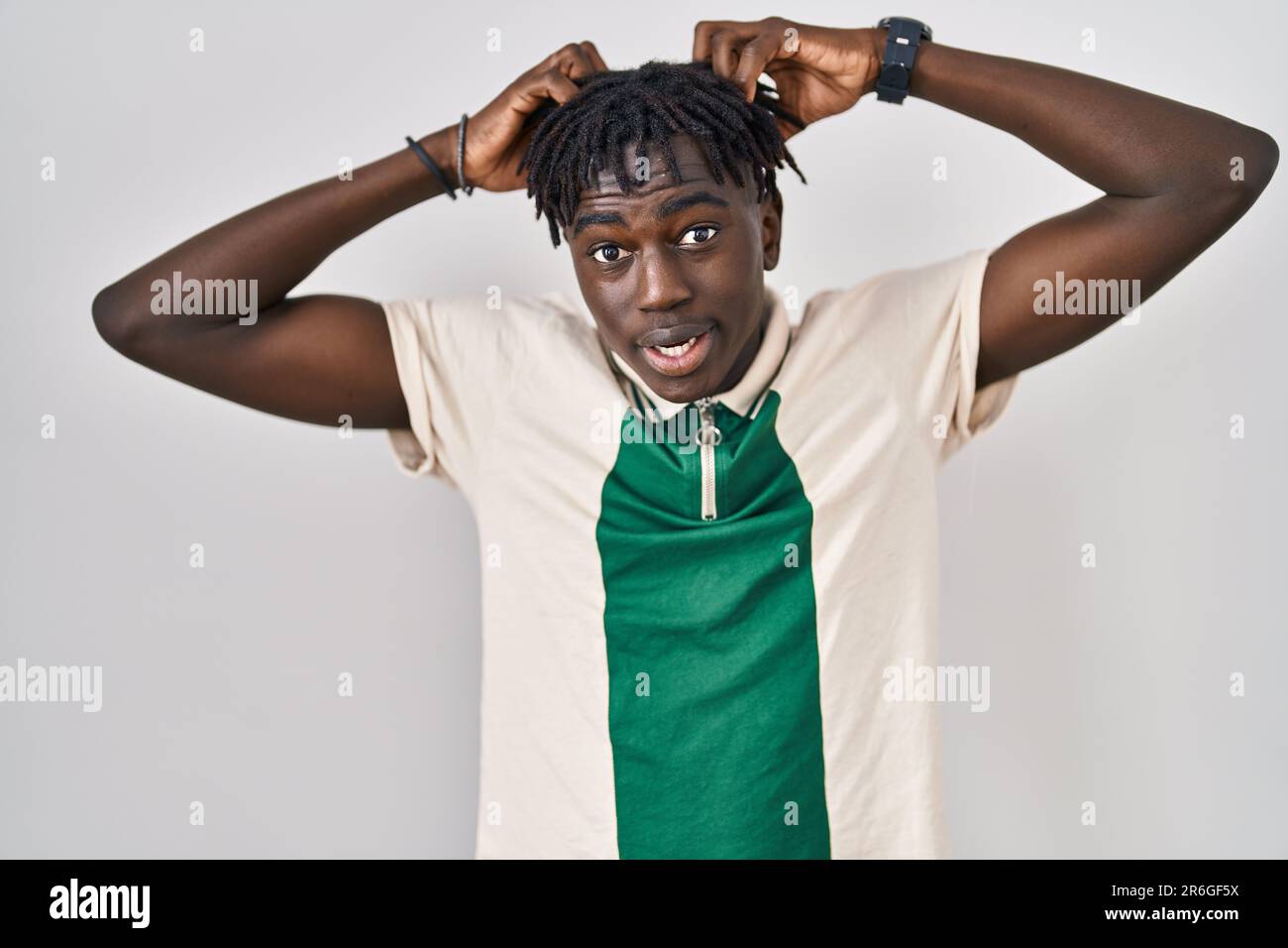 African man with dreadlocks standing over isolated background crazy and ...