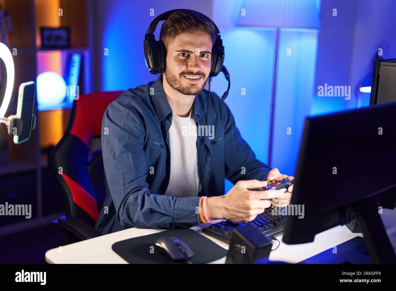 Young caucasian man streamer playing video game using joystick at ...