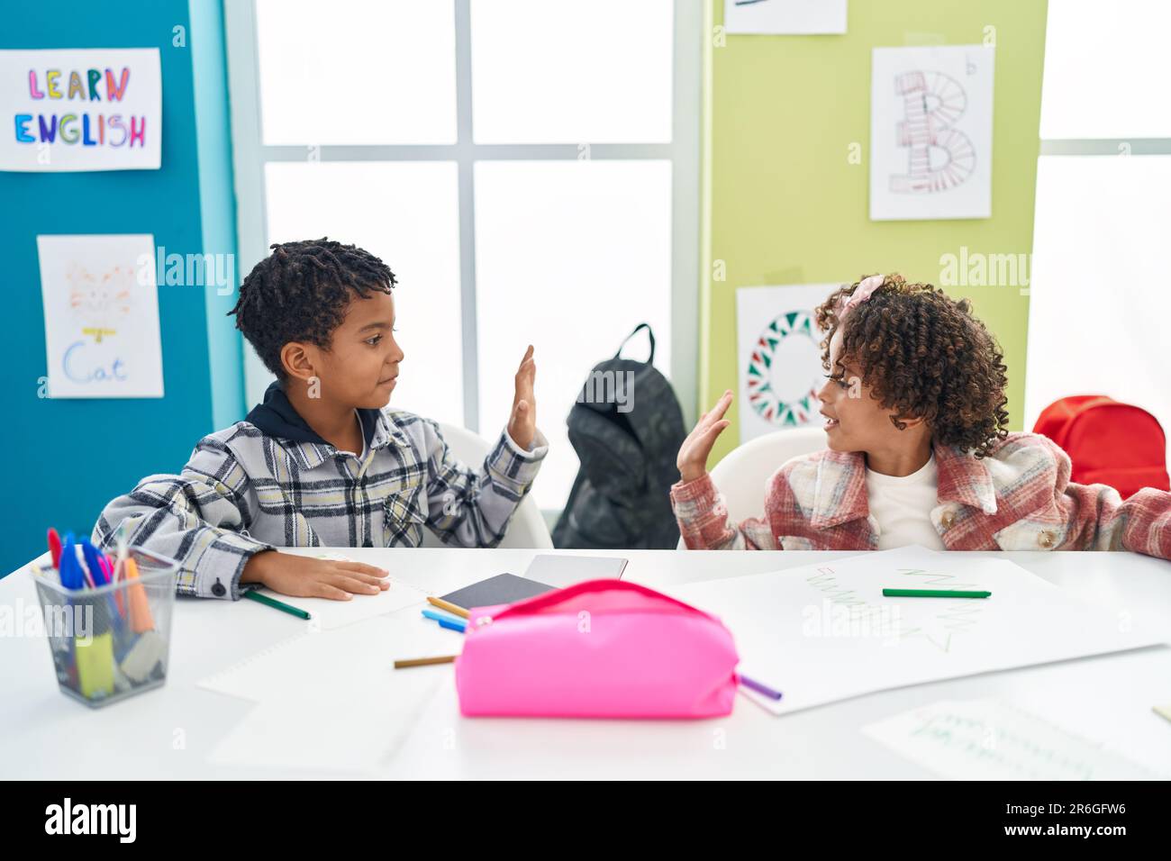 Adorable african american boy and girl students drawing on notebook ...