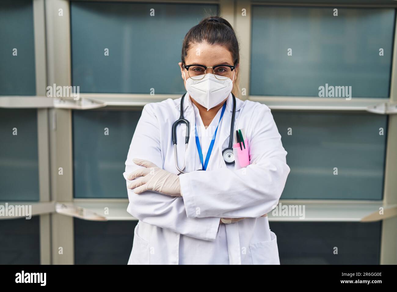 Young beautiful plus size woman doctor wearing medical mask standing ...