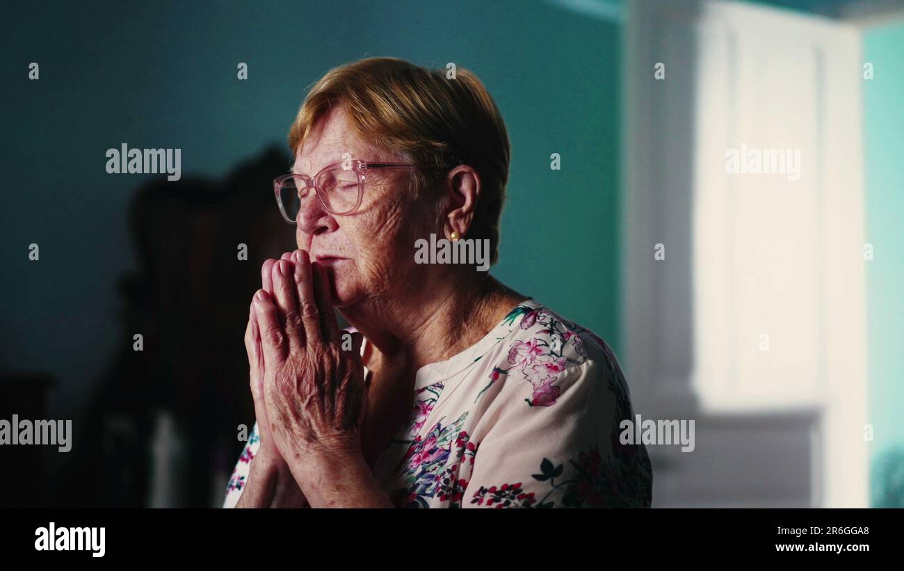 Religious older woman Praying to God in bedroom. Hopeful Elderly Mature ...