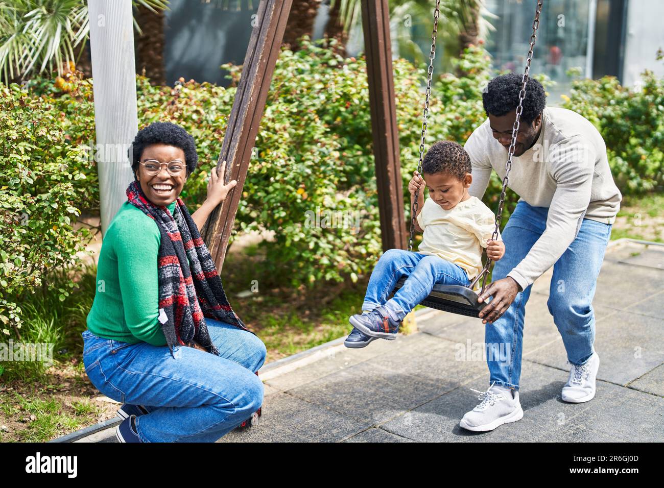 African american family playing on swing at playground Stock Photo - Alamy
