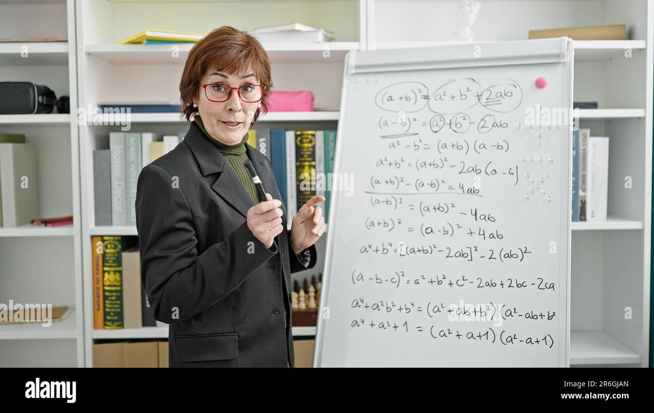 Mature hispanic woman teacher teaching maths lesson at library university Stock Photo - Alamy