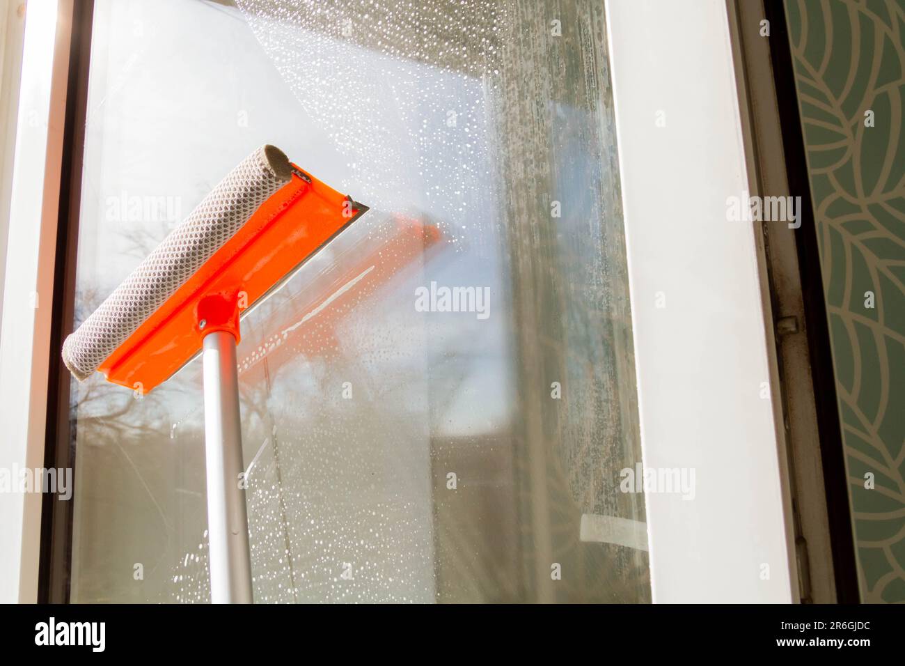 Window washing. Cleaning the window with a brush and foam. The concept ...