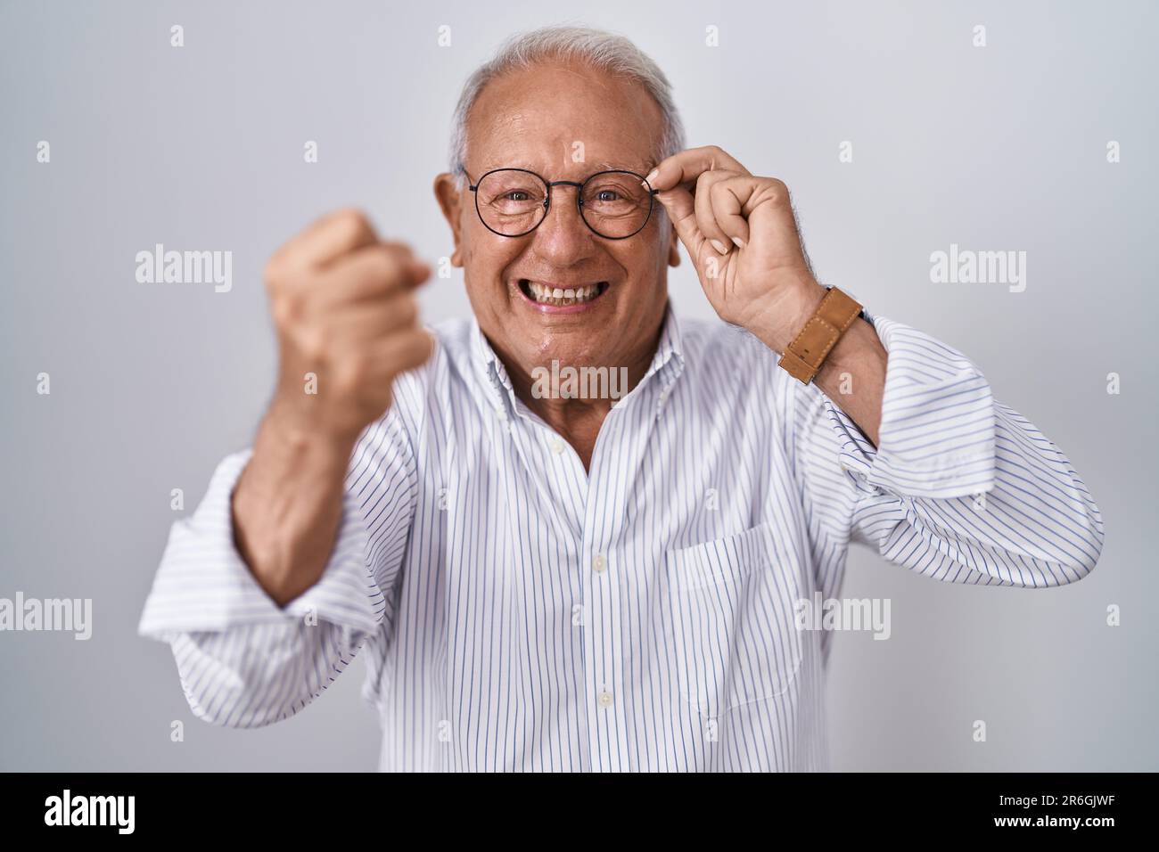 Senior man with grey hair holding glasses with hand annoyed and ...
