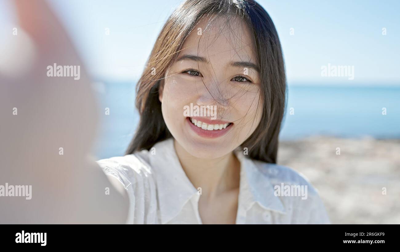 Young chinese woman smiling confident making selfie by the camera at seaside Stock Photo - Alamy