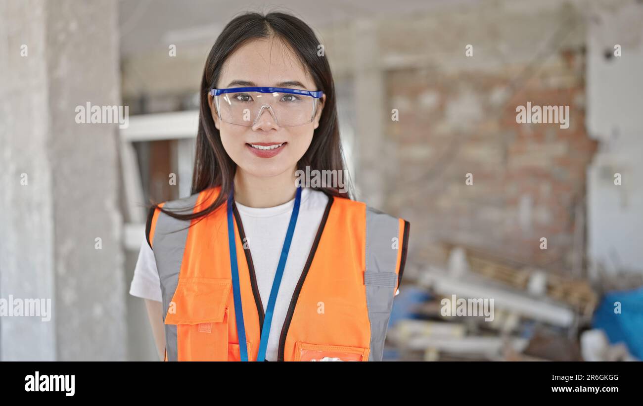 Young chinese woman builder smiling confident standing at construction ...