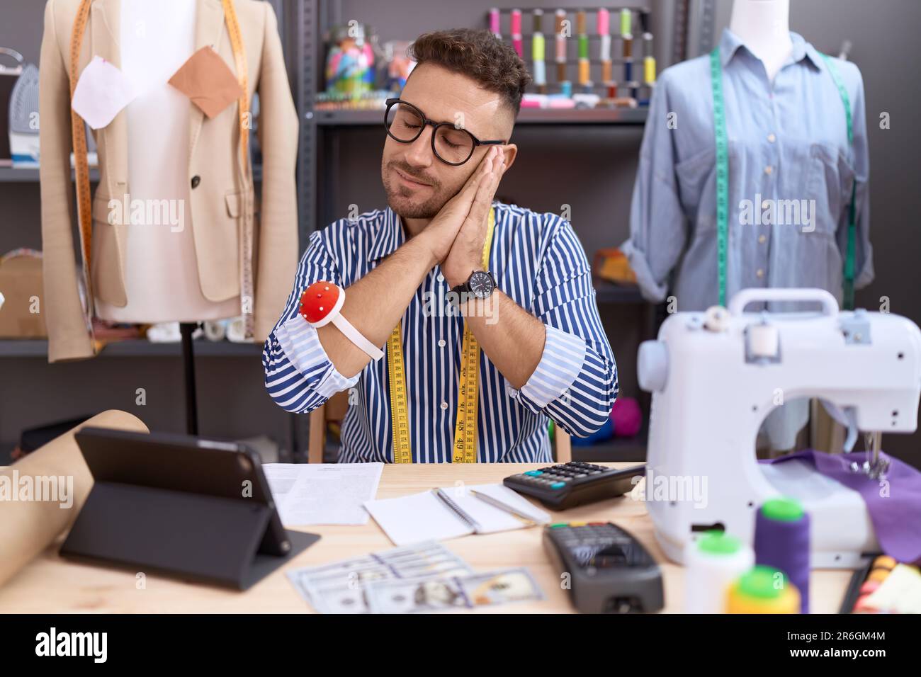 Hispanic man with beard dressmaker designer working at atelier sleeping ...
