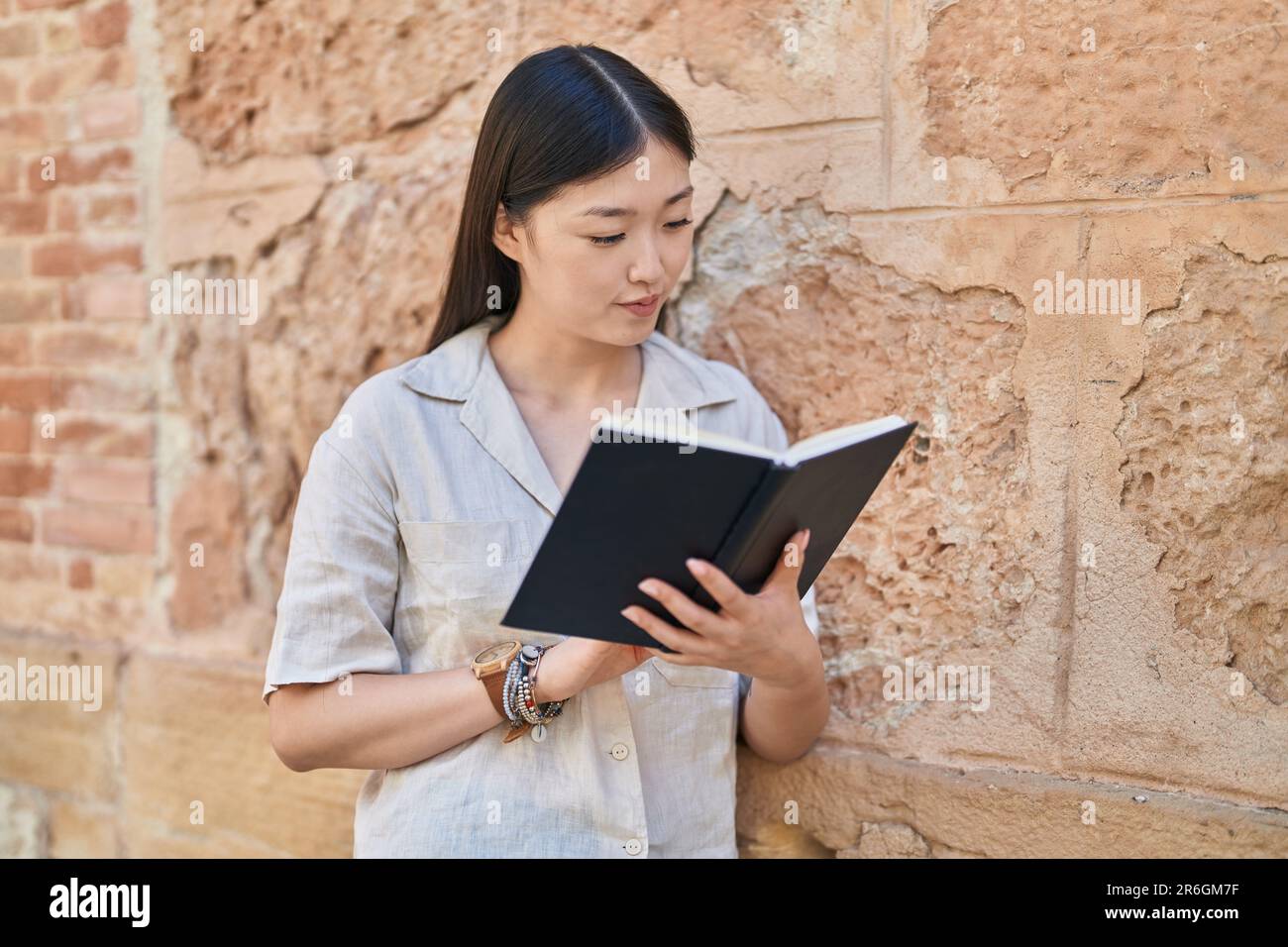 Chinese woman reading book at street Stock Photo - Alamy